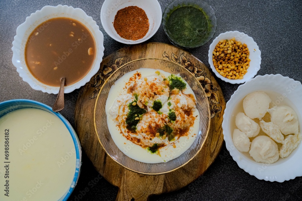 Dahi Bhalla with different kinds of sweet spicy chutneys and garnished ...
