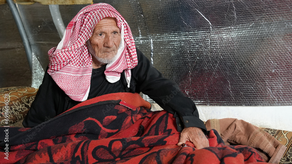 A crippled elderly man lives in a dilapidated tent. Displaced people in ...