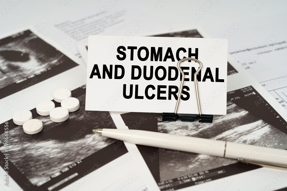 On the ultrasound pictures there is a pen and a business card with the ...