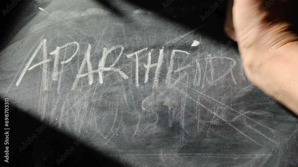 Hand writing the word racism, discrimination, apartheid, colourism ...