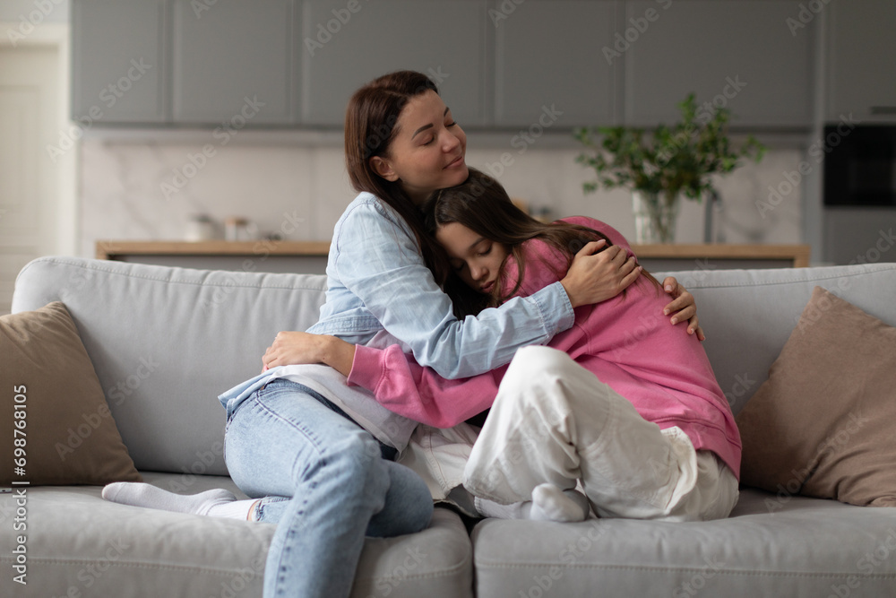 Loving mother hugging teen daughter, mom showing understanding and support to upset sad teenage ...