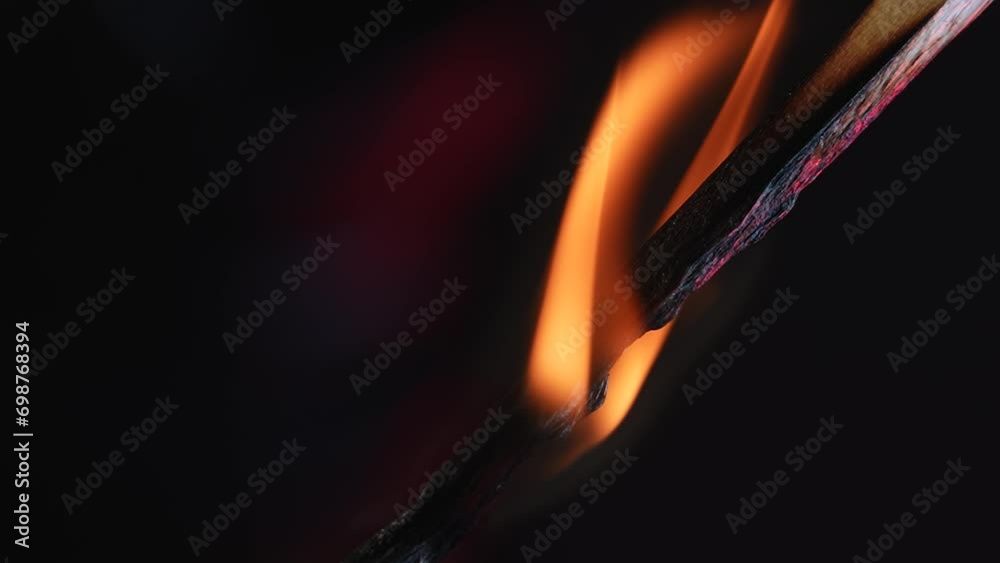 Burning match on black background of studio. Flame sizzles the wooden ...