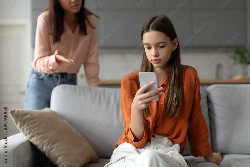 Angry Mother Shouting And Arguing With Teenage Daughter Over Use Of