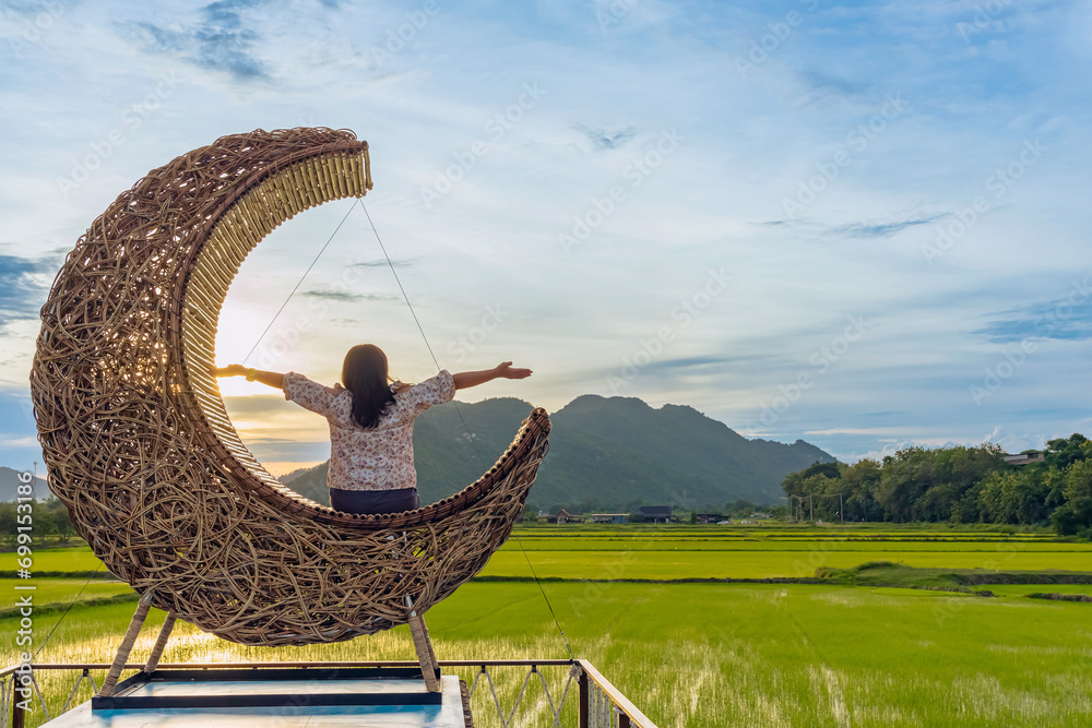 Woman sit on crescent moon chair made of rattan for relaxation on ...