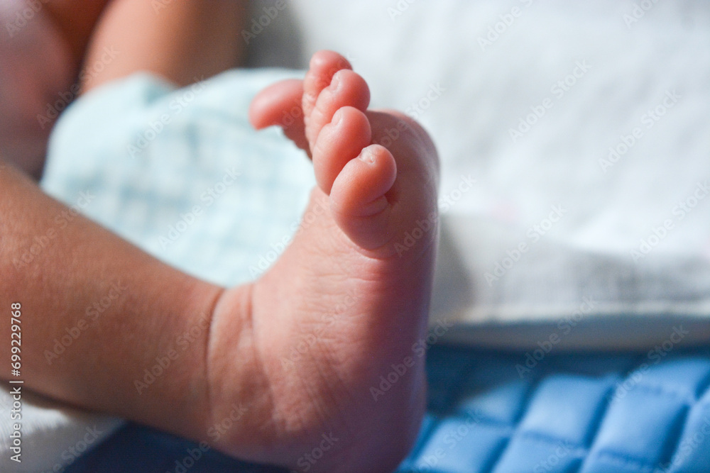 Newborn baby's feet are still very small. The baby's feet are held by ...