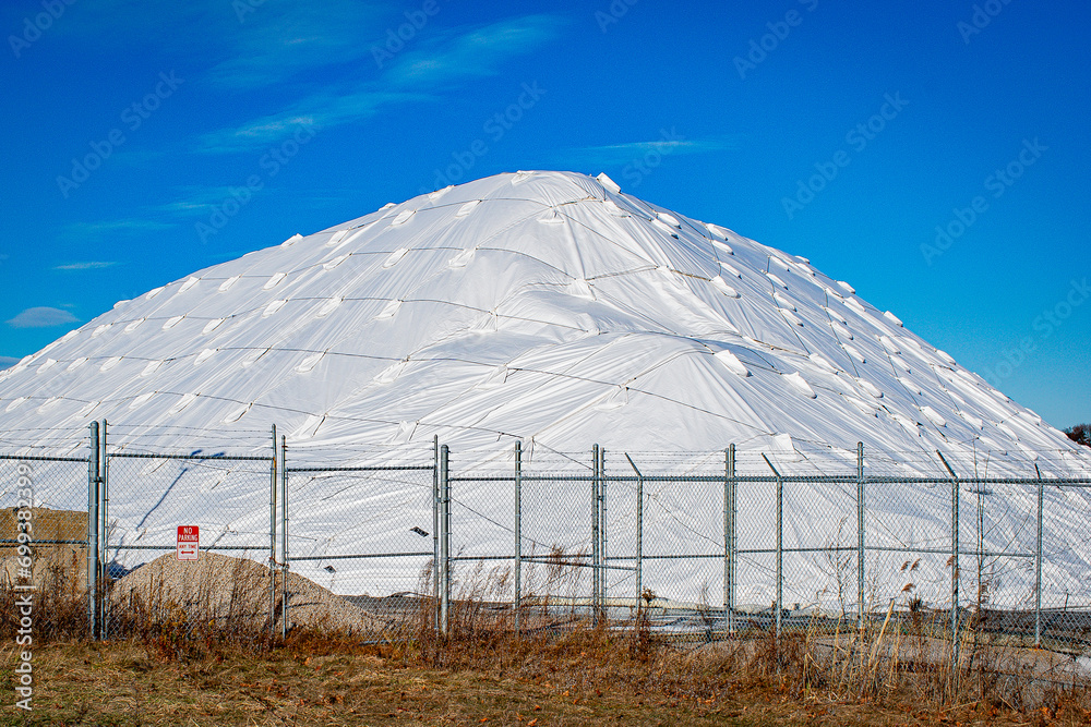 Road salt covered with a giant white tarp with a blue sky background ...