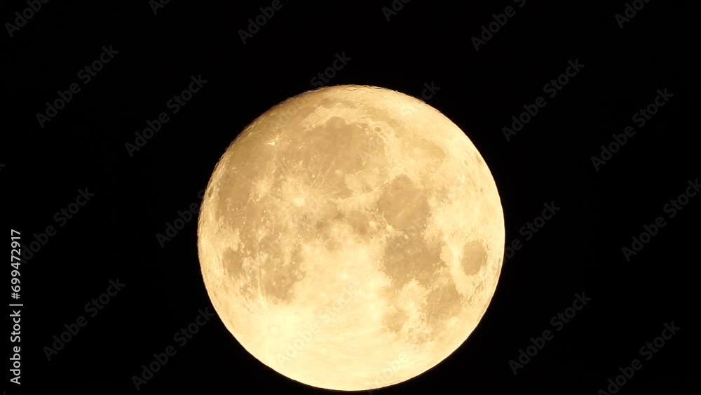 A glowing golden huge full moon seen from earth through the atmosphere ...