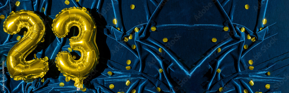 number twenty three, gold foil balloon number on blue velvet background ...