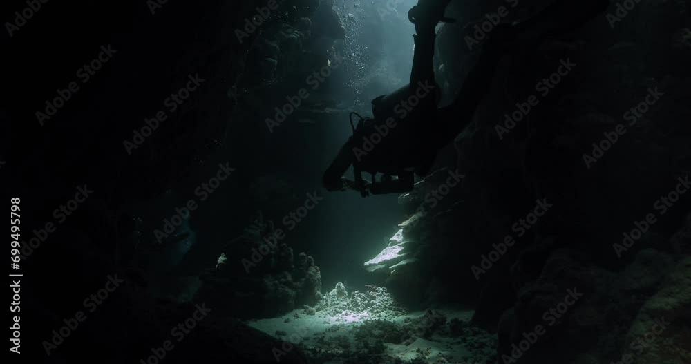 a diver is using a small camera to film the subaquatic environment ...