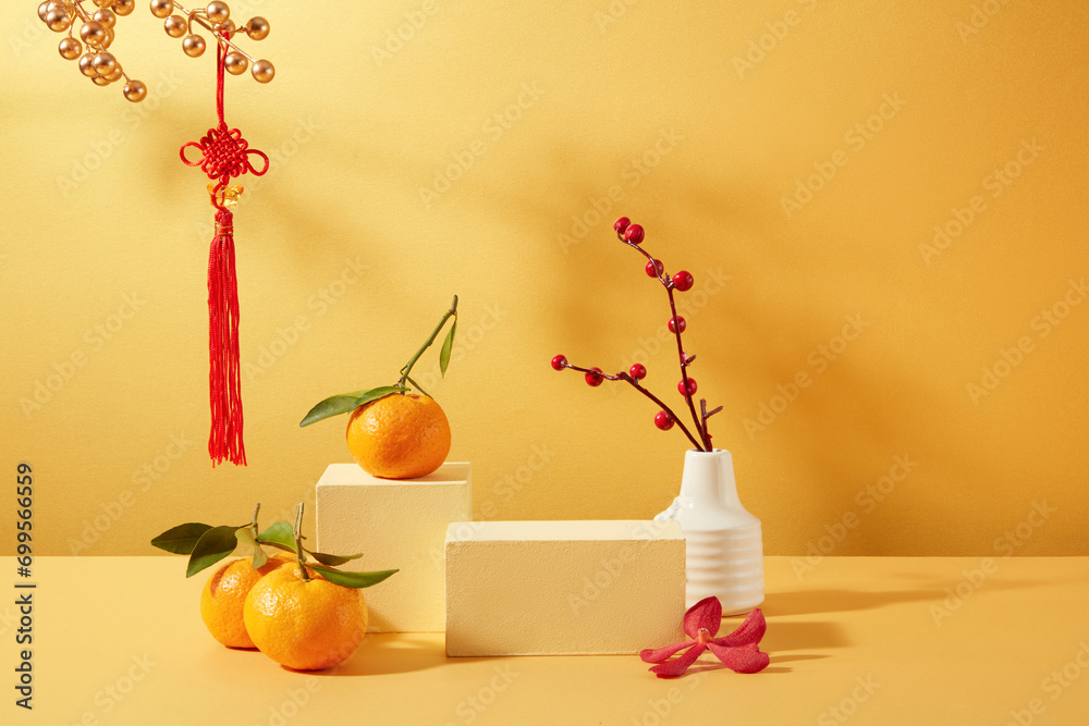 Tangerines, two wooden platforms, a flower vase and Tet decorations are ...