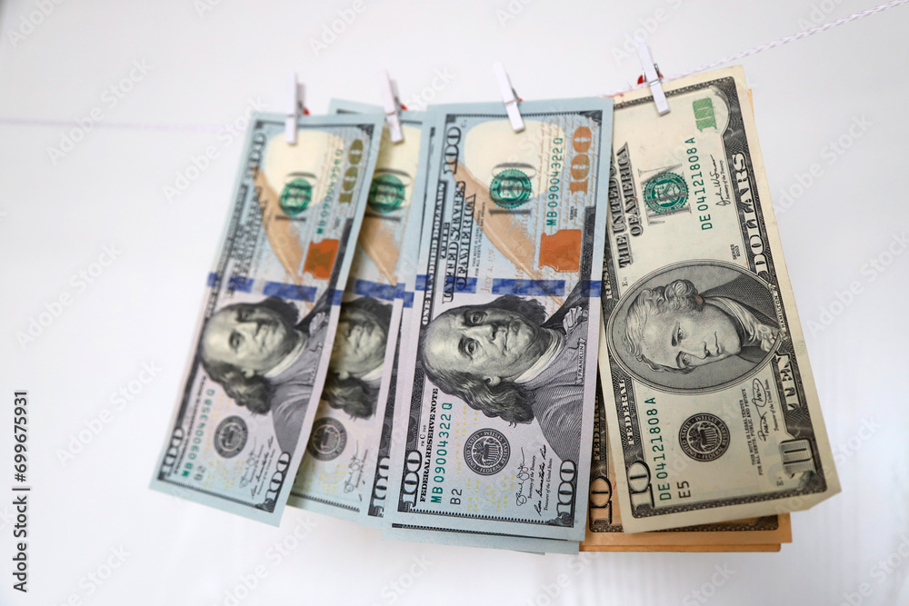 100 dollar and 10 dollars bills hanging to dry on a washing line ...