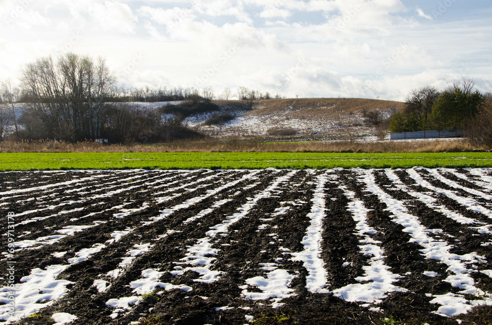 Plowed field under snow, black photo of rows of soil before sowing ...