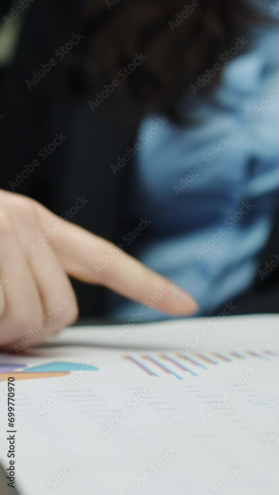 Vertical screen: Hands of people working with papers together, checking ...