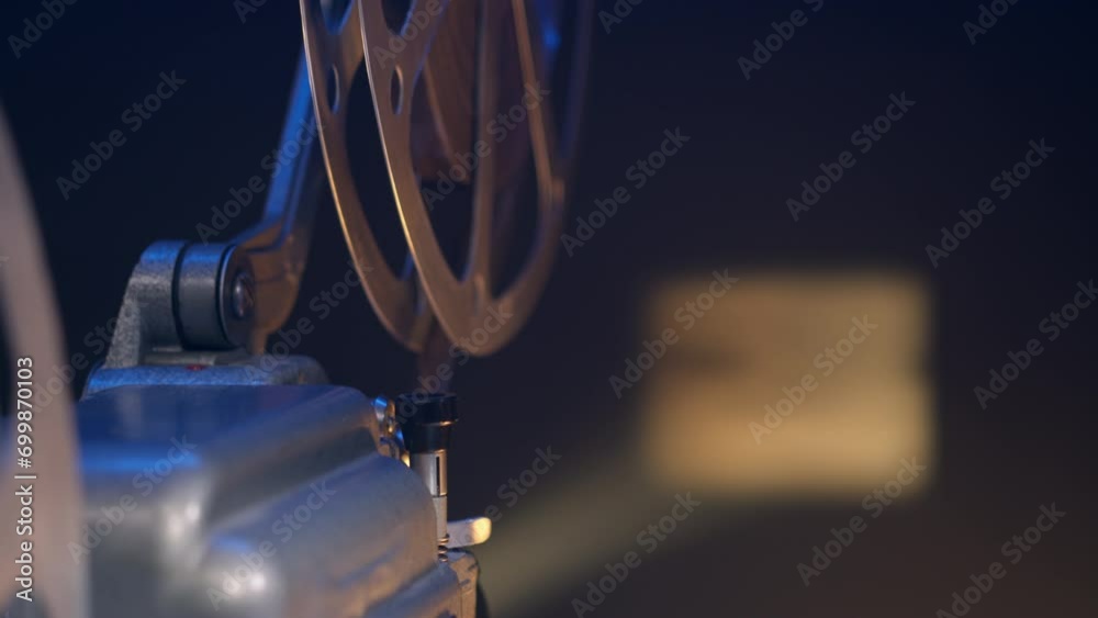 close up of antique movie projector projecting film on screen. 16mm ...