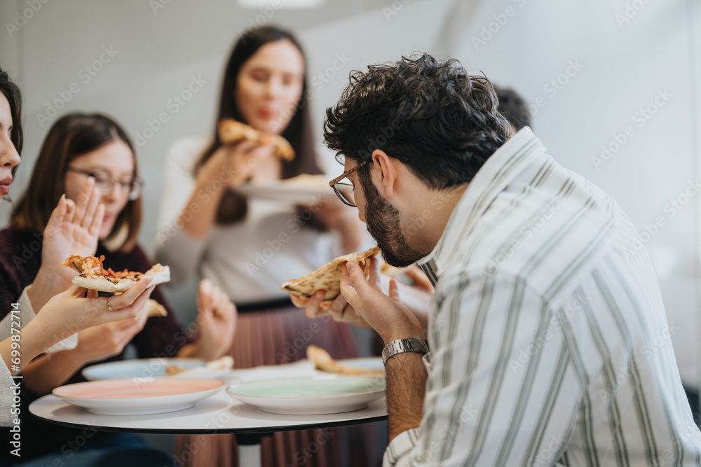 Multigenerational and diverse group of coworkers enjoying a pizza lunch ...
