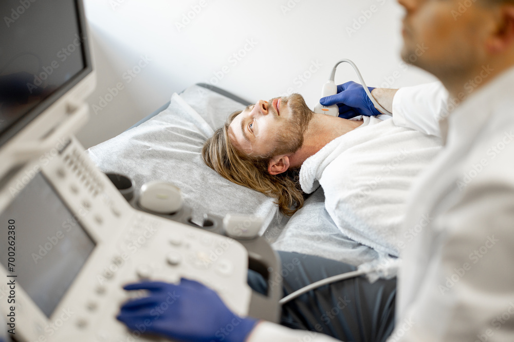 Young guy during an ultrasound diagnosis of the carotid artery. Concept ...