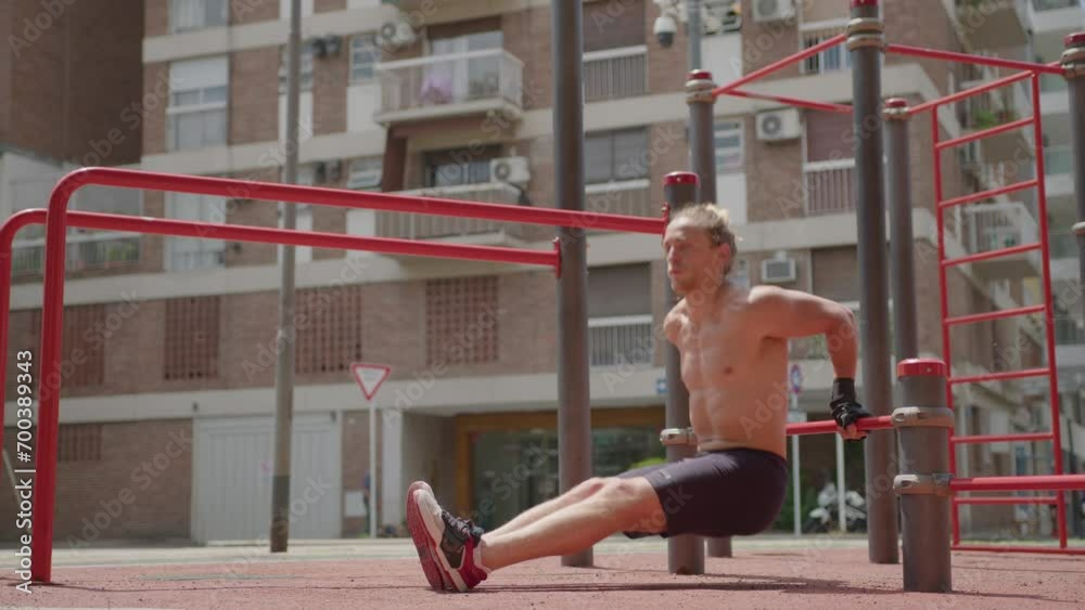 Strong man with shirtless muscular torso performing tricep dips ...