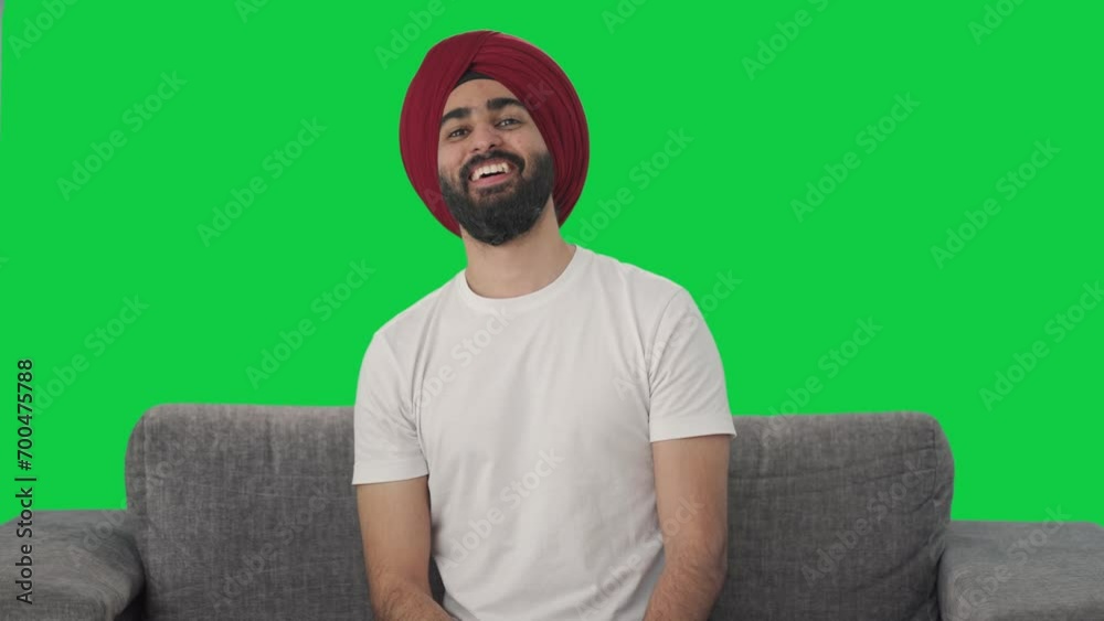 Indian Sikh Indian man laughing while watching TV Green screen Stock ...