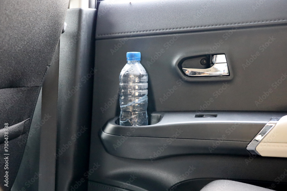 cup holder in car. a plastic drinking bottle tucked into the bottle ...