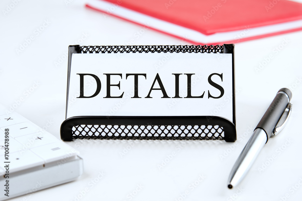 DETAILS the word on the business card standing on a stand next to a ...