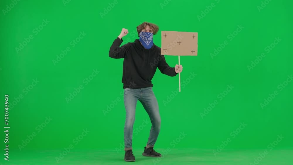 Male activist with face covered by scarf, shouting protest slogans and ...