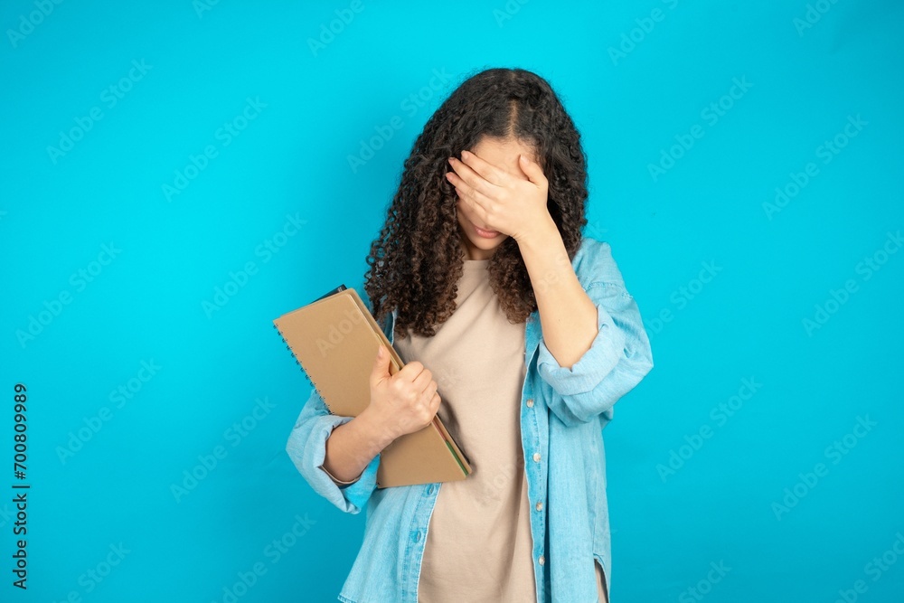 beautiful teen girl covering her face with her hands, being devastated ...