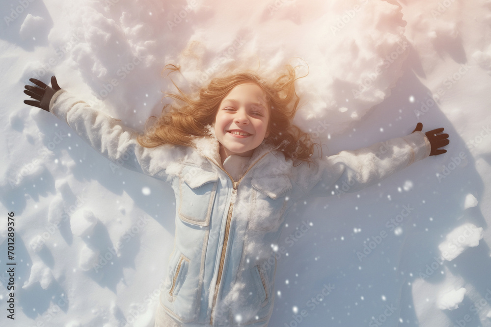Happy teen girl lying with arms spread on snowdrift under sun. Red ...