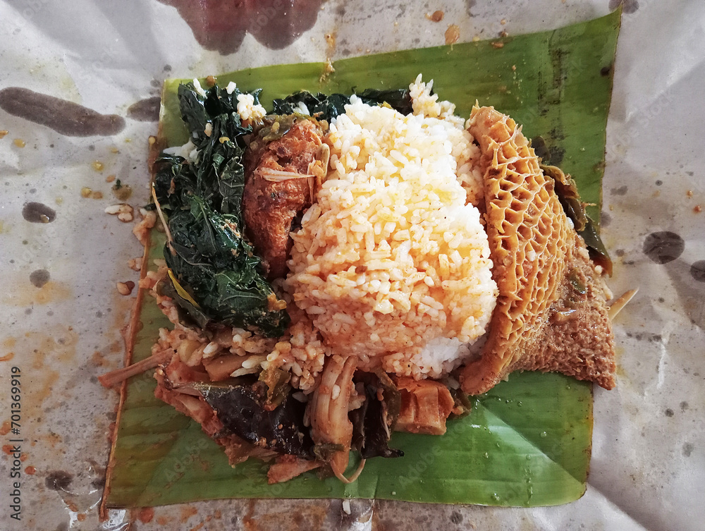 Padang rice or "Nasi Padang" with rice siram broth, side dishes of ...
