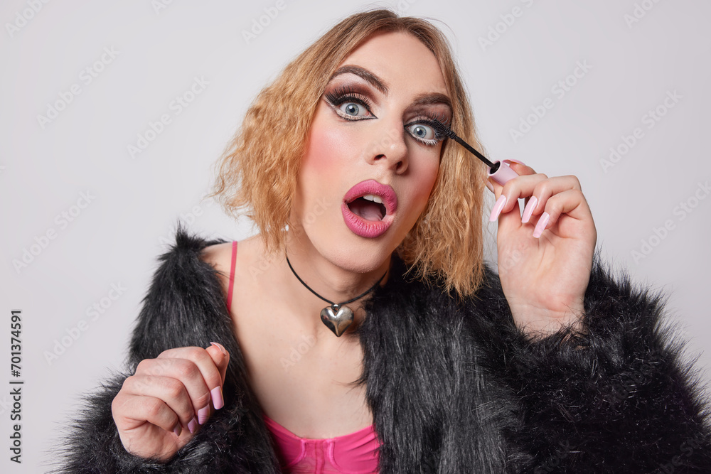 Photo of transgender guy with bob hairstyle applies mascara to his ...