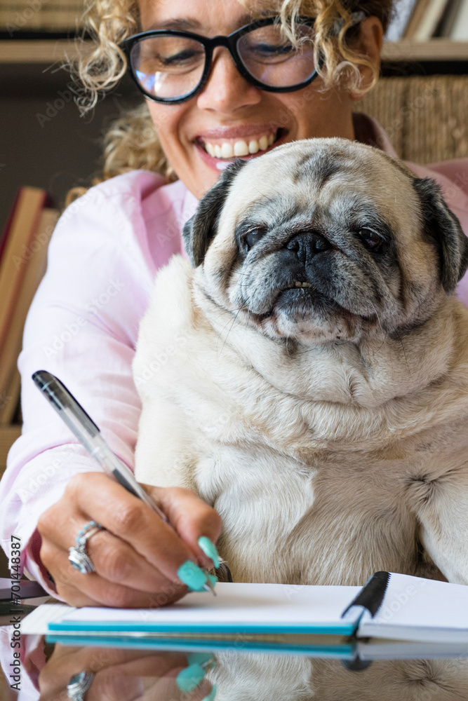 Happy woman at home in love for her best friend pug dog while work at ...