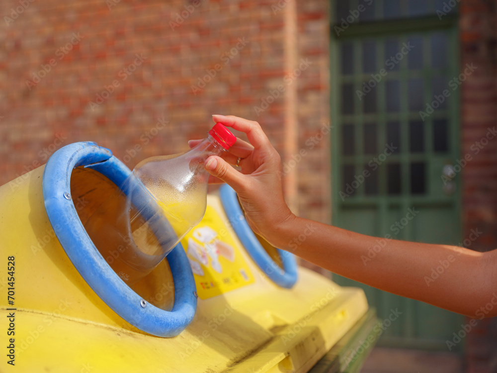 woman throwing plastic bottle Recycling bin stand on european street ...