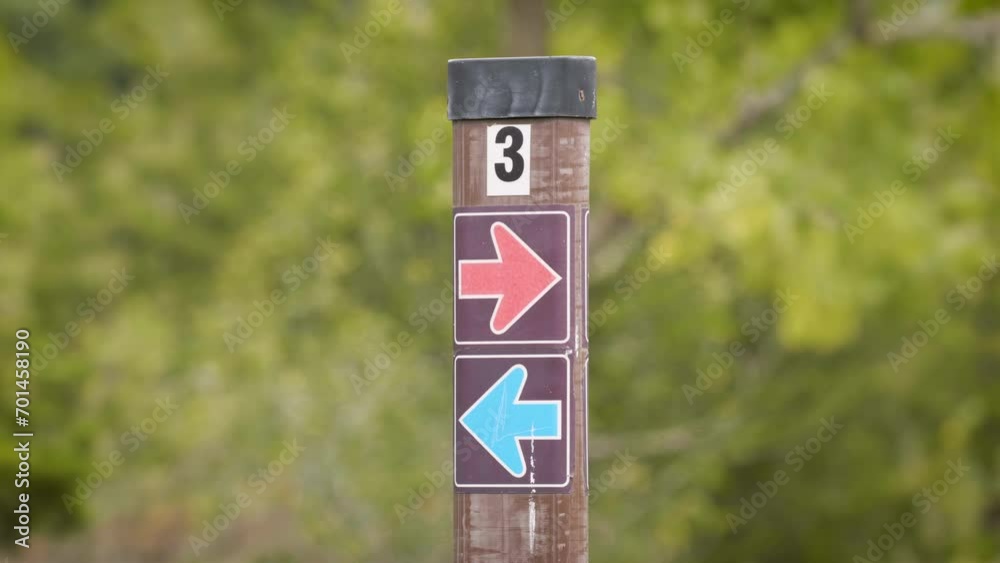 Trail marker indicates direction of pathways in nature preserve, shot ...