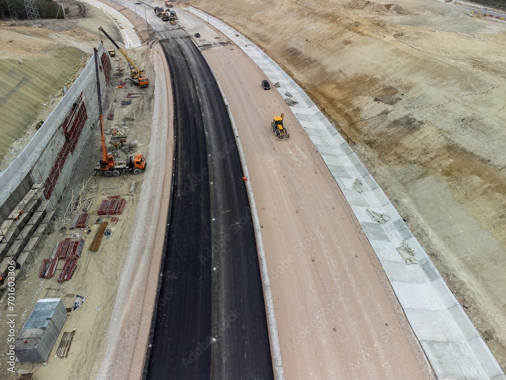 Mountain road constraction. Workers reinforce the slope over the new ...