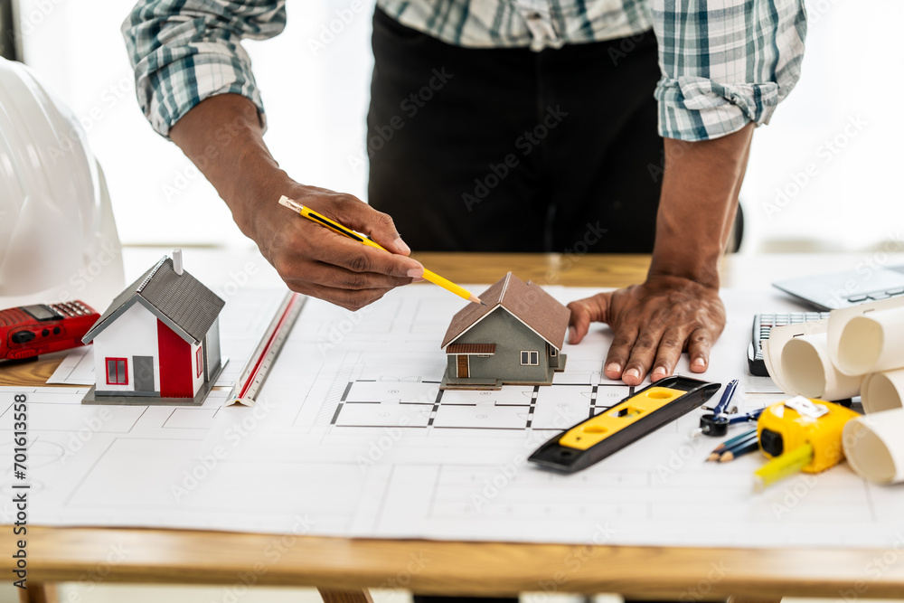 Asian person hands working on architectural blueprints with a pencil ...