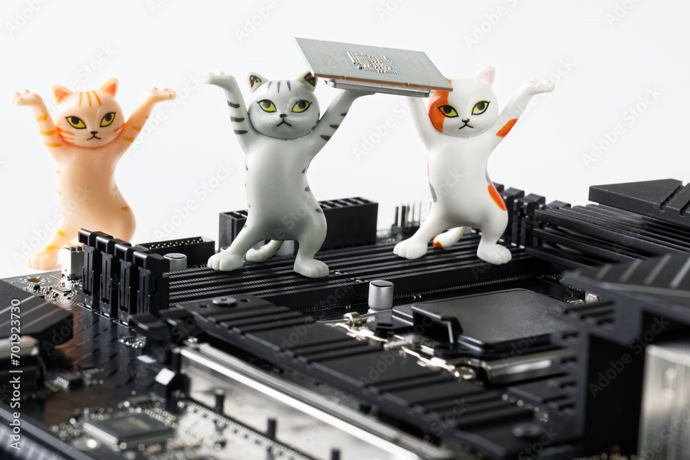 Three funny toy kittens mount a processor into a modern socket on a ...