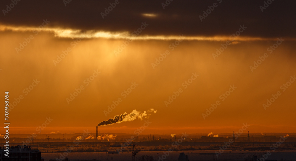 Plumes of factory smoke rise from the chimneys into the sky at sunset ...