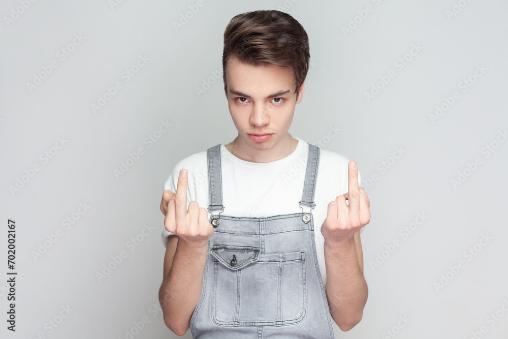 Portrait of rude impolite young brunette man standing shows middle ...