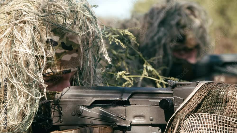 Snipers in an ambush in the grass, disguised as terrain on an anti ...