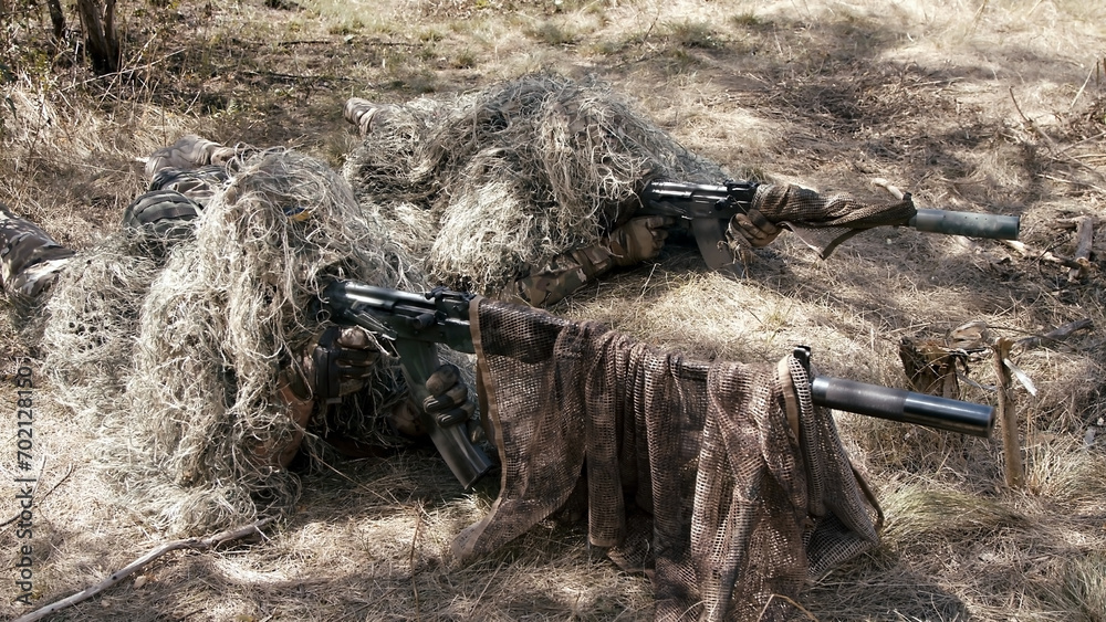 Snipers in an ambush in the grass, disguised as terrain on an anti ...