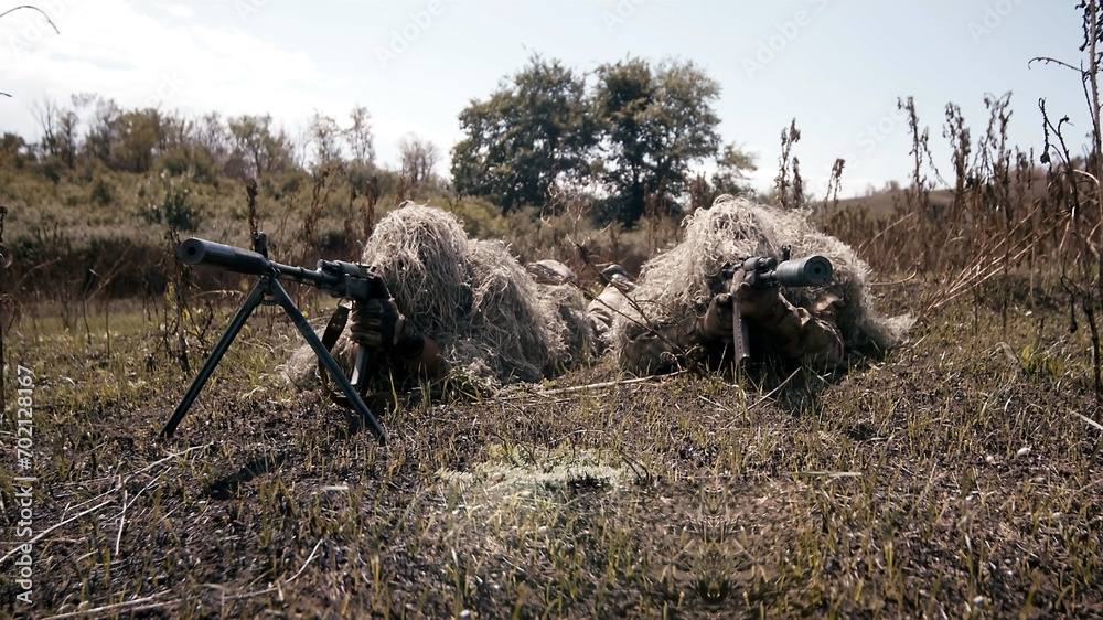 Snipers in an ambush in the grass, disguised as terrain on an anti ...