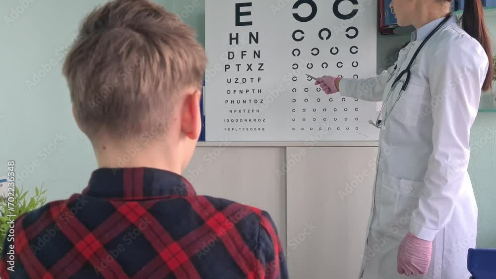 Ophthalmologist holds pen to check vision of teenage boy child. Eye ...