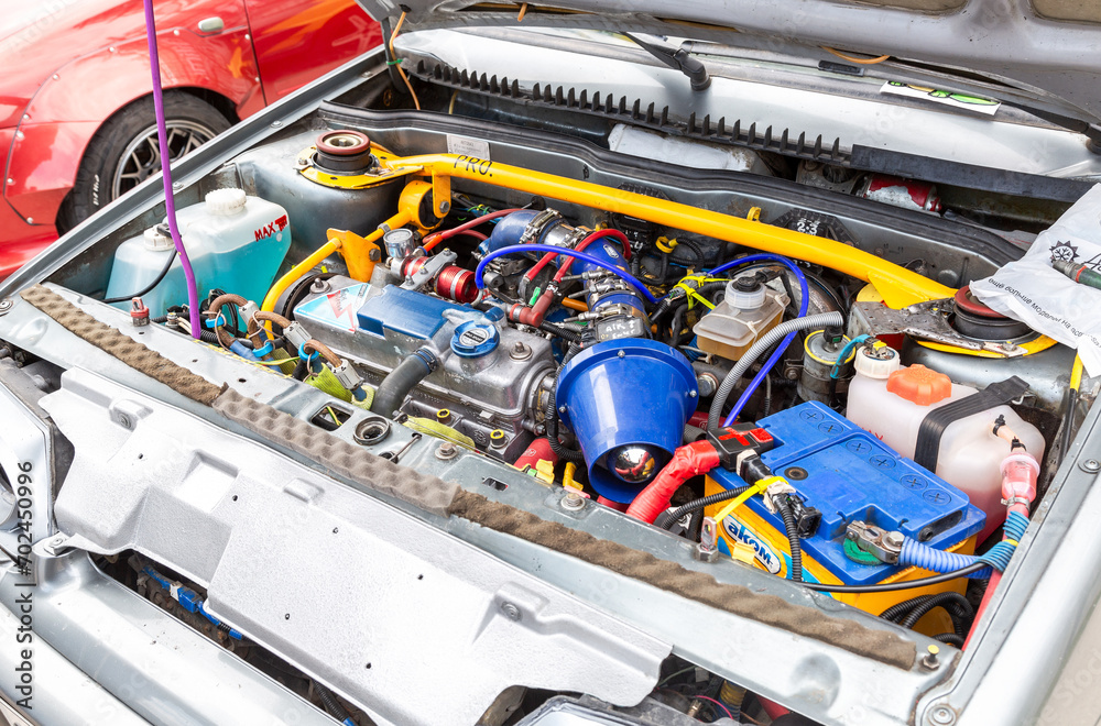 Engine under the hood of a tuning Lada vehicle with a variety of ...