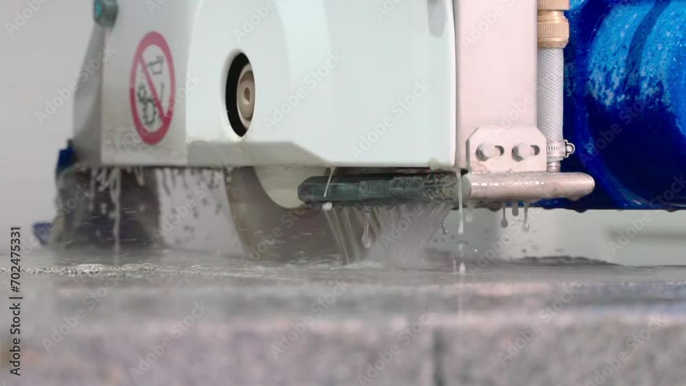 Automated saw is cutting the stone into the small slabs in a production ...