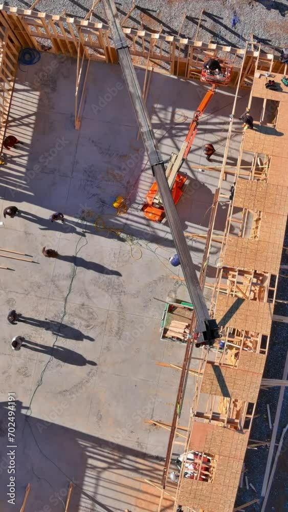 Crane installation of wooden roof trusses at new residential building ...