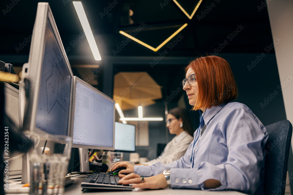 Side view of an architect working on blueprints and project at office ...