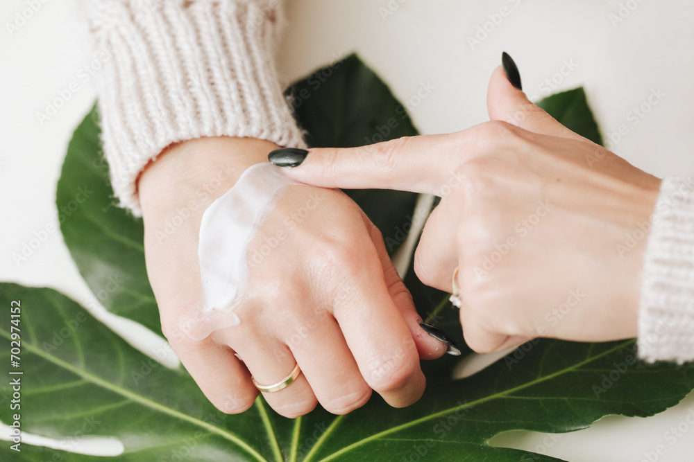 Skin care background. Hand cream use. Closeup of wet skin. Green leaf ...