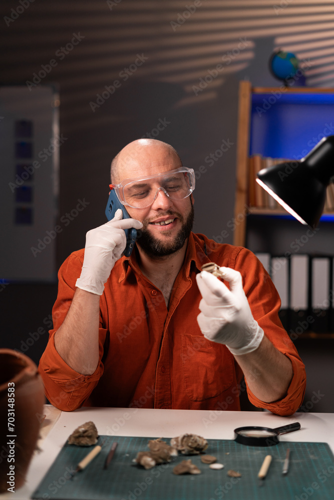 Archaeological office. Male archaeologist doing research, uses ...