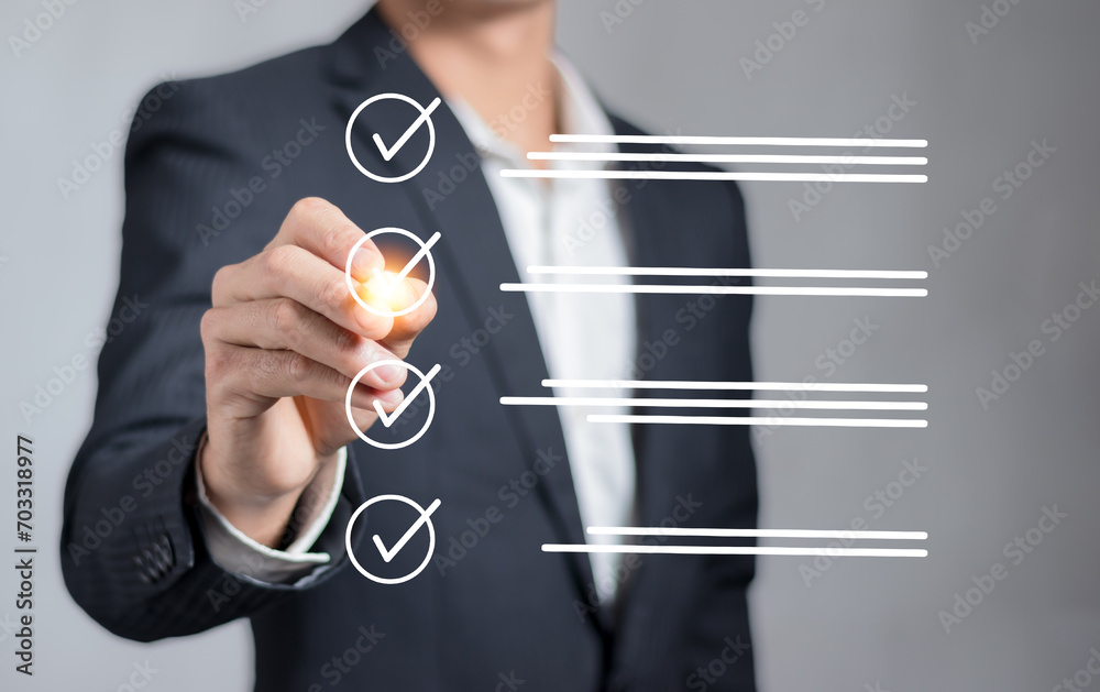 Businessman using pen to tick correct sign mark in checkbox for quality ...