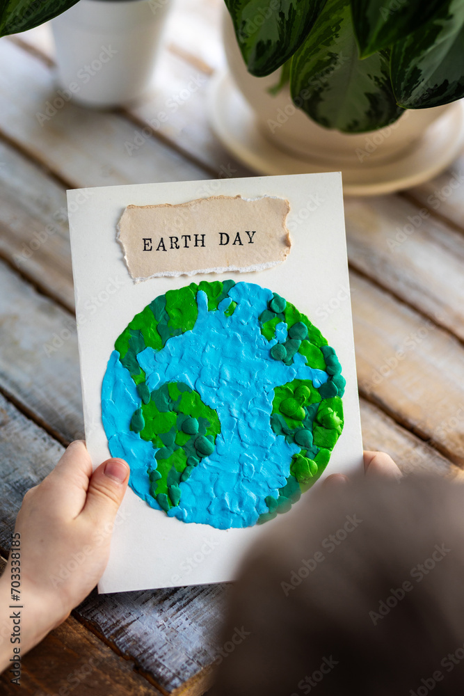 Children's craft for the Earth Day celebration. Little boy holding ...