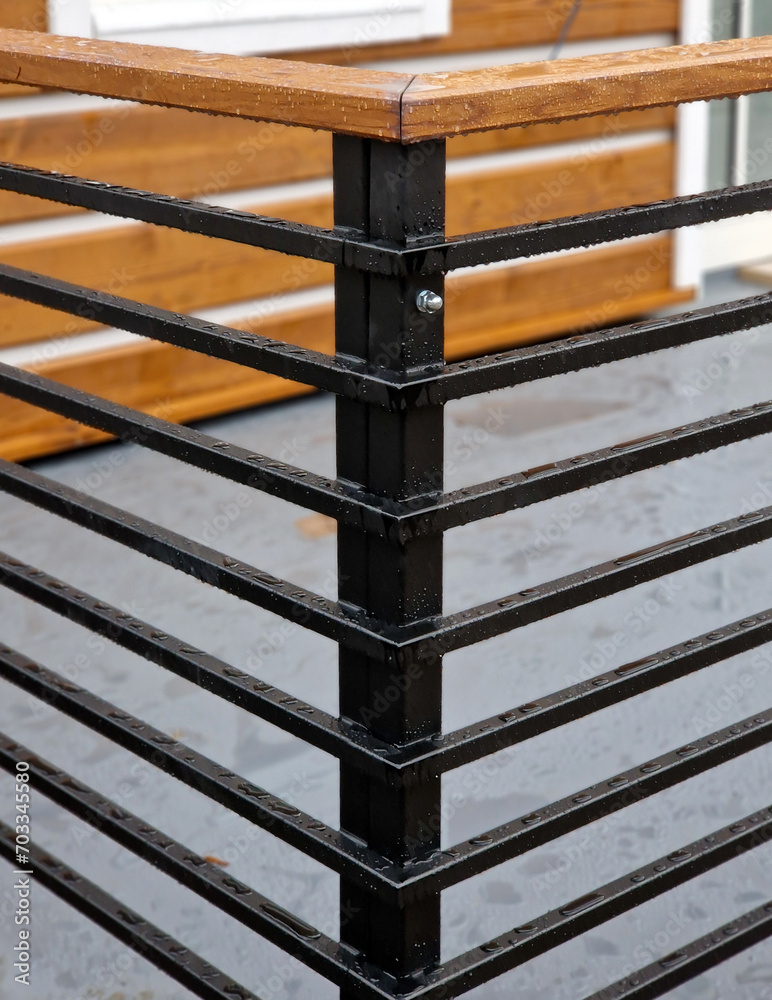black railing with metal longitudinal section and handle made of wood ...